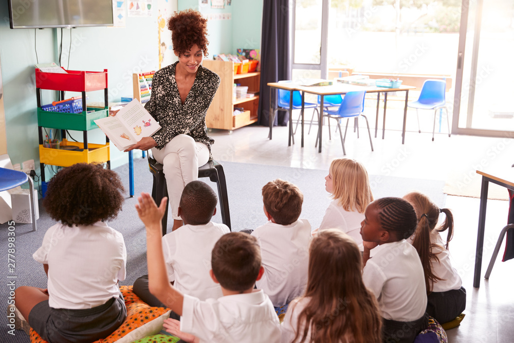 Elementary Pupil Wearing Uniform Raises Hand To Answer Question As ...