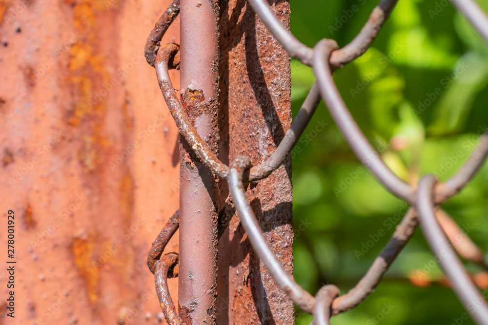 Rows of wire mesh and rusty metal pillar of fence. Wire mesh grid ...