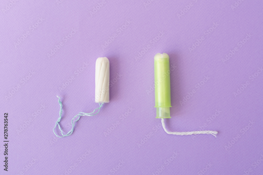 Two cotton tampons with light green applicator and without applicator ...
