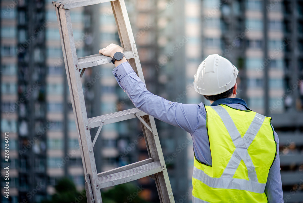 Asian maintenance worker man with safety helmet and green vest carrying ...