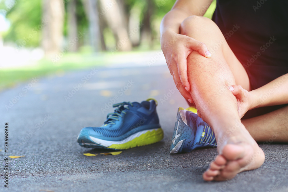 Runner touching painful twisted or broken ankle. Athlete runner ...