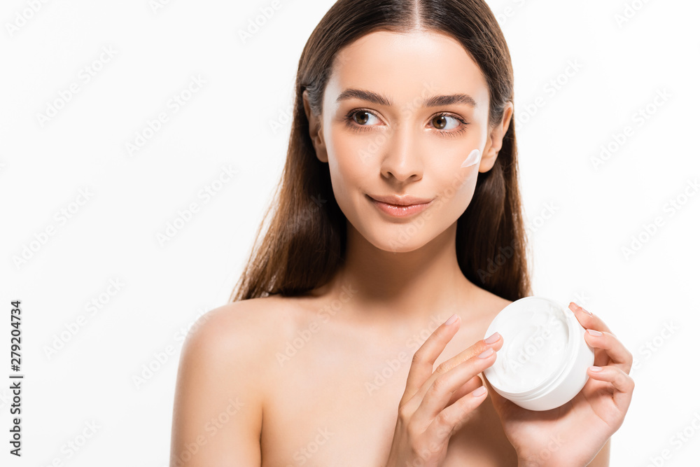 beautiful young naked woman with perfect skin and cosmetic cream on face looking away isolated ...