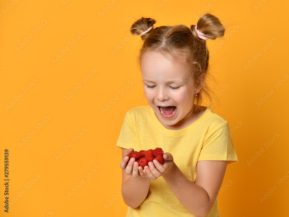 Young baby girl kid hold berries fruits in hands surprised happy ...