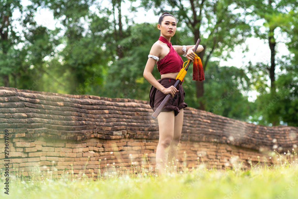 Asian woman warrior in Ayutthaya costume holding sword fight. Warrior woman of soldier of Bang ...
