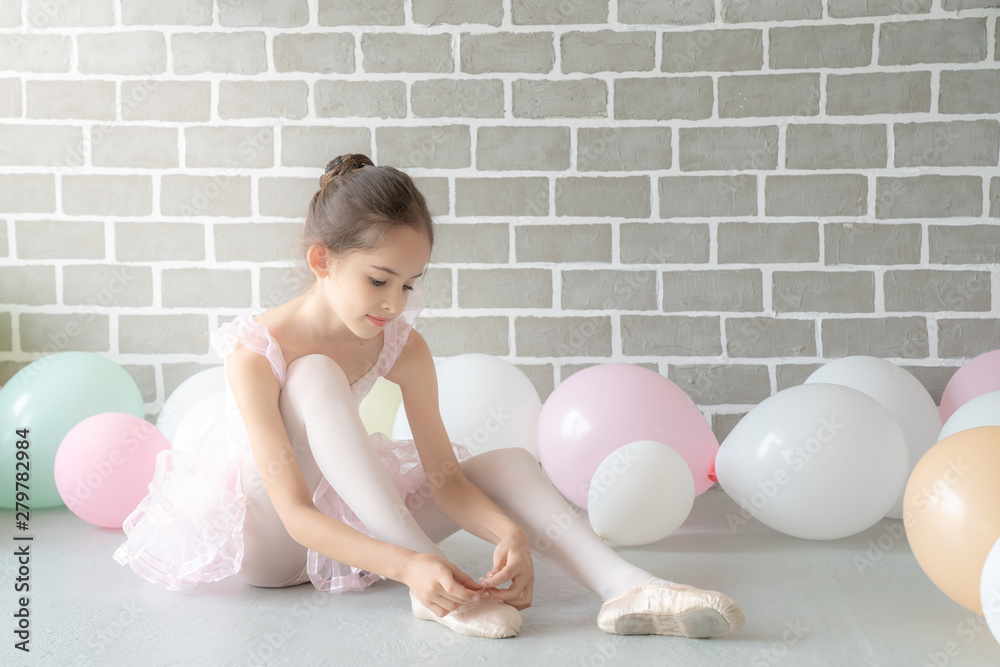 Cute beautiful young little girl ballerina dancer in pink leotard and tutu ballet dress costume ...