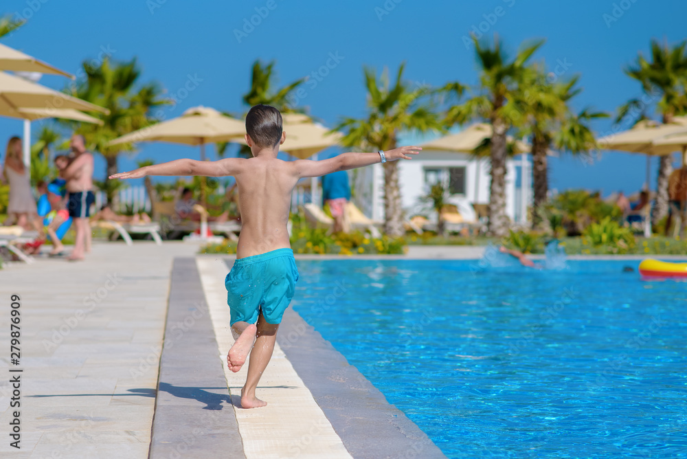 Smiling Caucasian boy having fun in swimming pool at resort on family ...