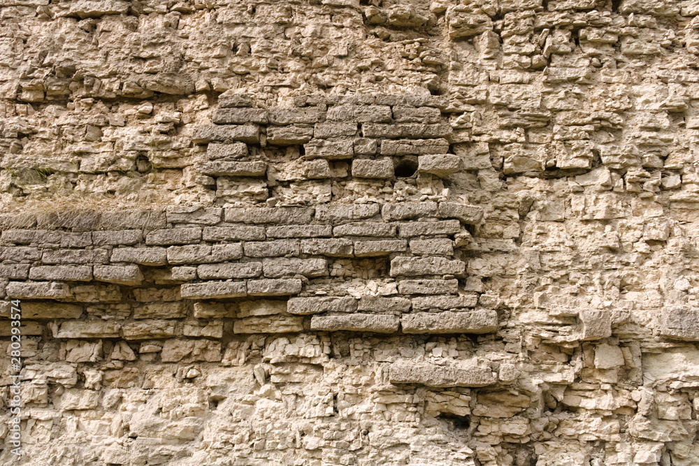 The texture of the broken fortress wall of hand-crafted bricks of gray ...