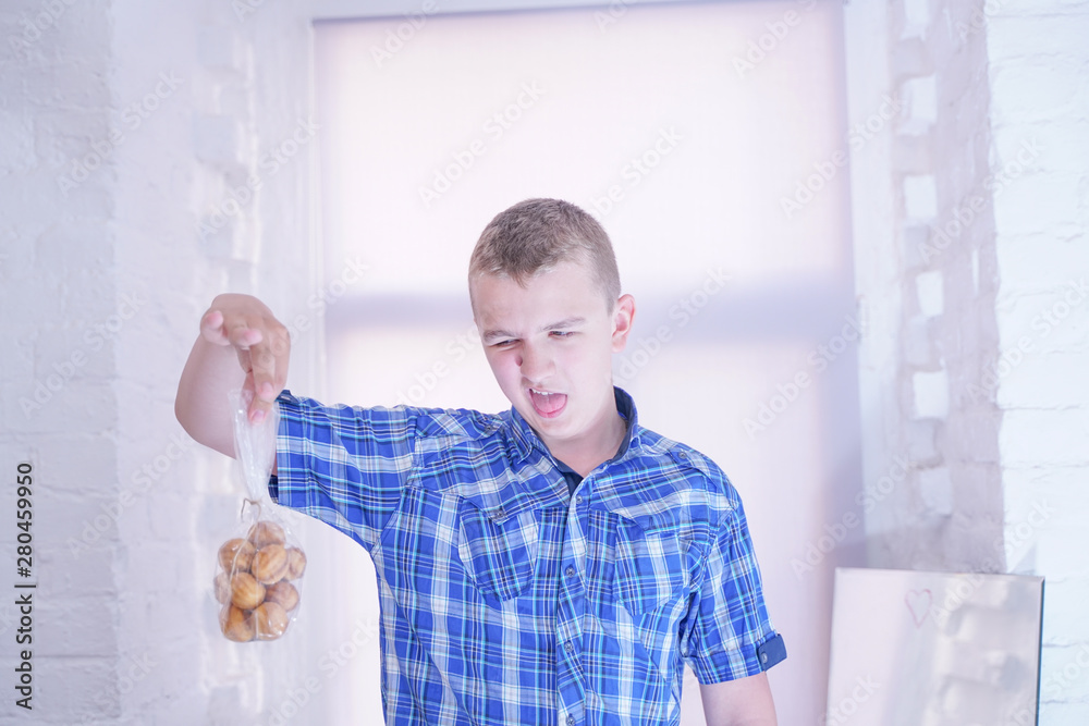 cute hungry teenager boy with fresh small bake sweets on white room ...