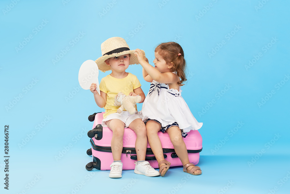 Happy kids sitting on colorful pink suitcase prepared for summer ...