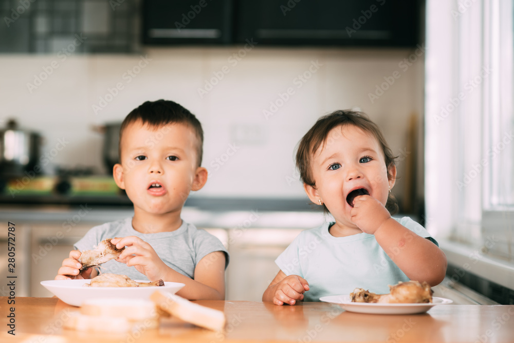 Kids boy and girl , brother and sister in the kitchen having fun and ...