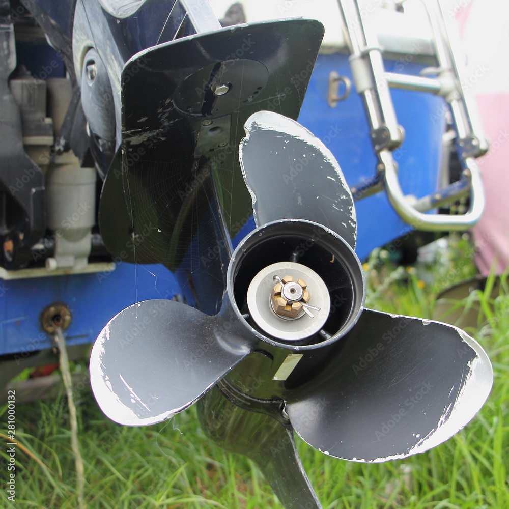 Close up lower unit of boat transom outboard motor - black used 3 blade ...