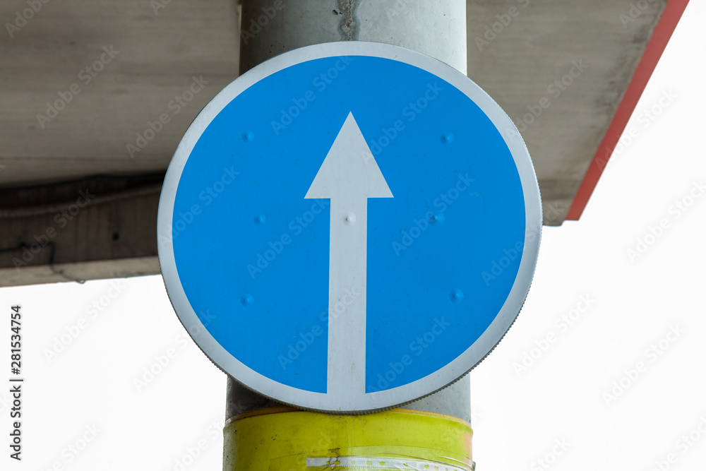 White arrow on blue background of round traffic sign. An entry ...