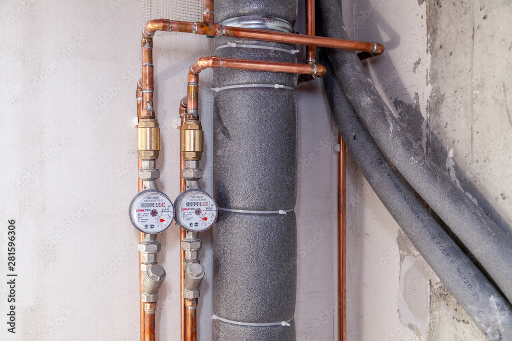 Closeup many copper and sewer gray plastic pipes, red valves, fittings ...
