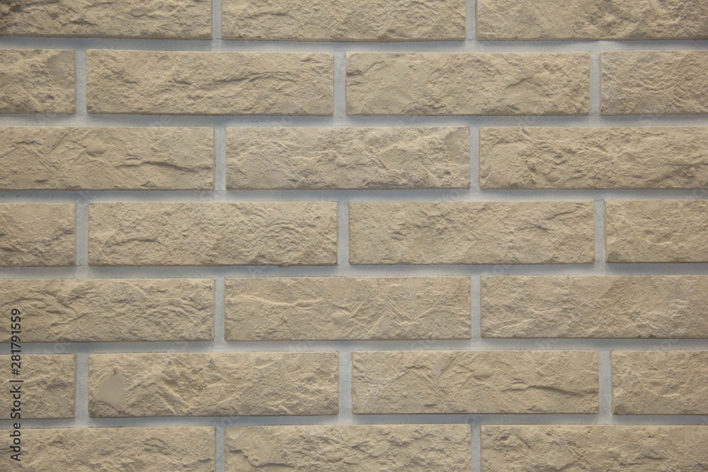 light brown stone brick exterior wall in hard light emphasizing stone's ...