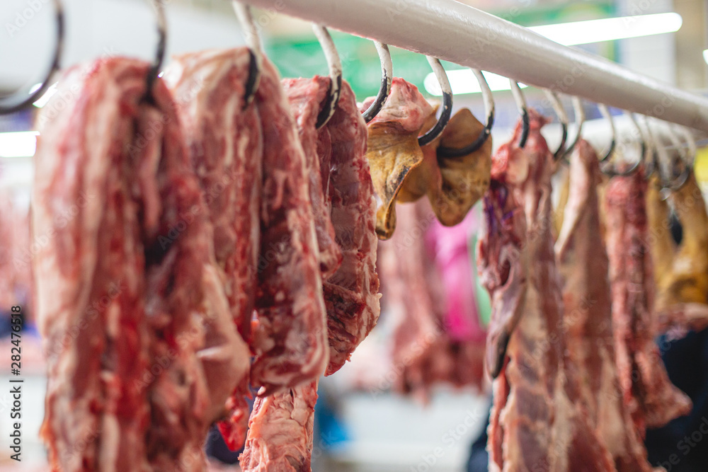 pieces of pork, veal and mutton hanging and lying side by side on the ...