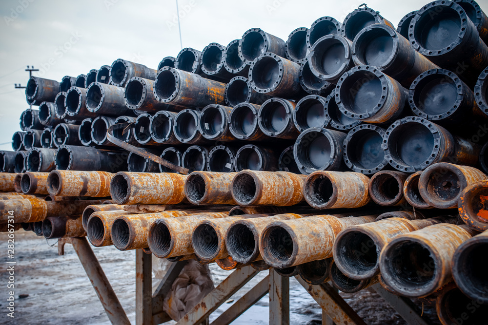 Drill pipe of oil drilling platforms. Stack of oil well casing bundles ...