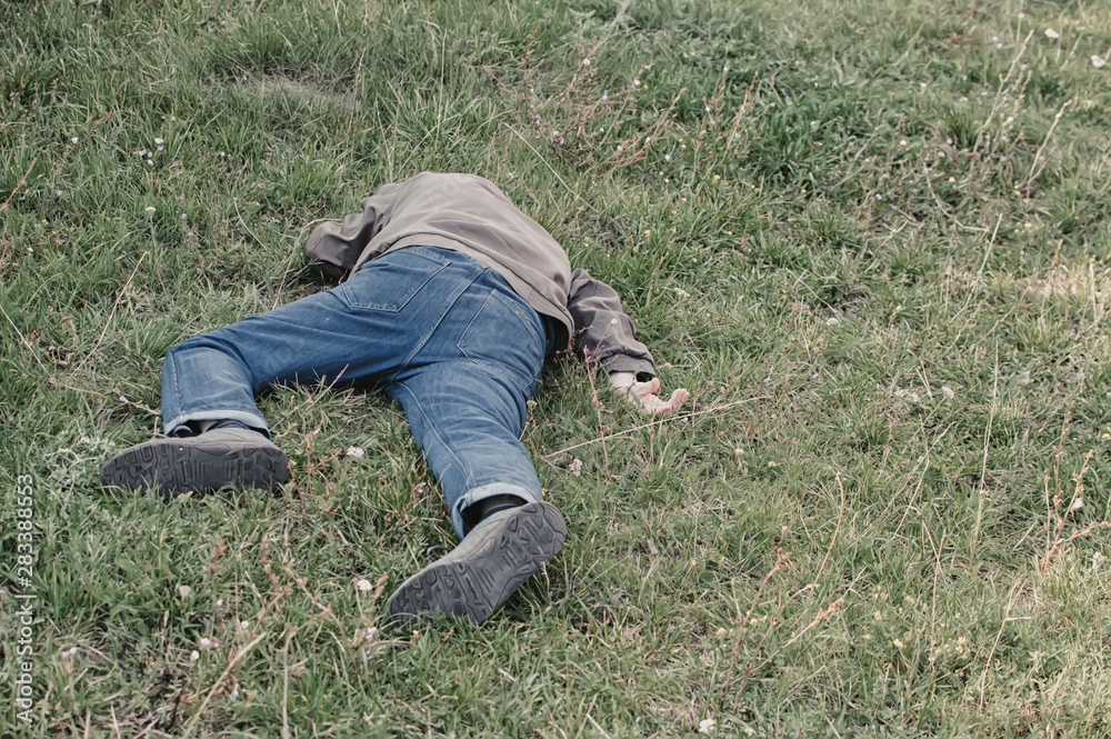 The corpse of a tramp in the grass. Criminal. Alcoholic intoxication ...
