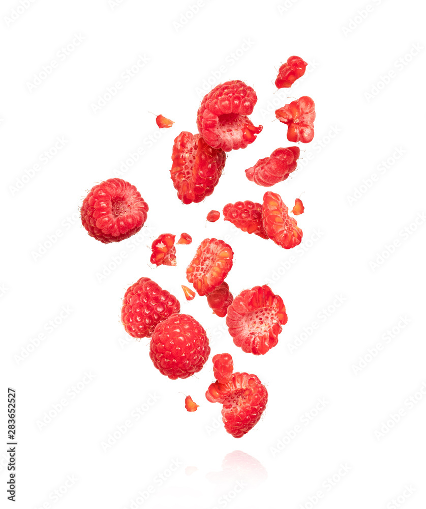 Whole and sliced raspberries in the air, isolated on a white background ...