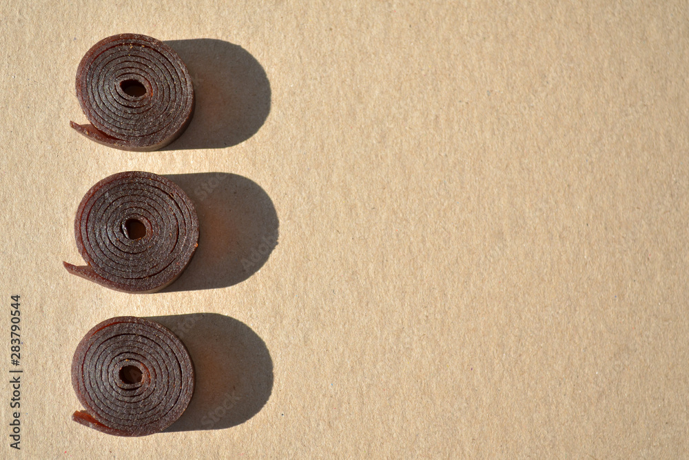 Three pieces of round pastille rolled up on a roll, they are lying ...