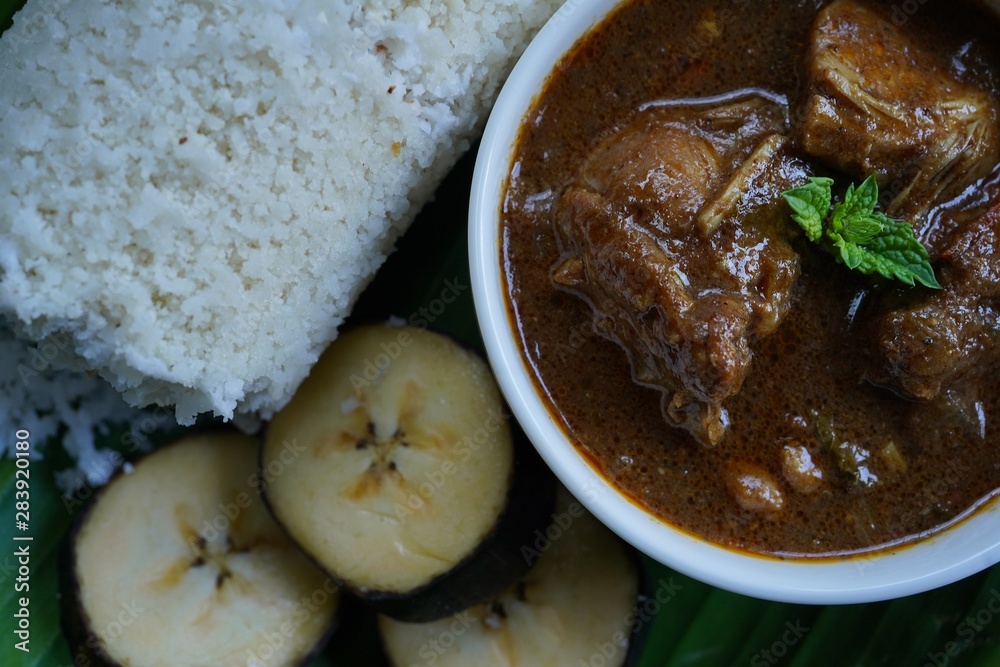 Popular South Indian breakfast steamed rice Puttu with Chicken curry ...