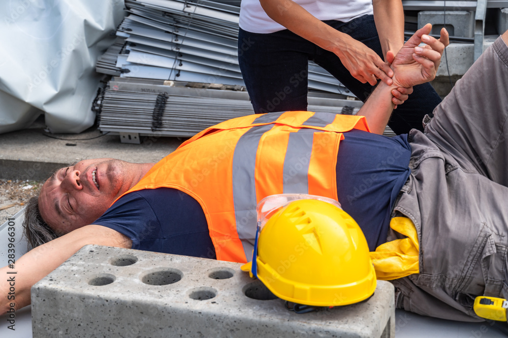 Cropped image of a paramedic's hands checking the pulse rate of a lying ...