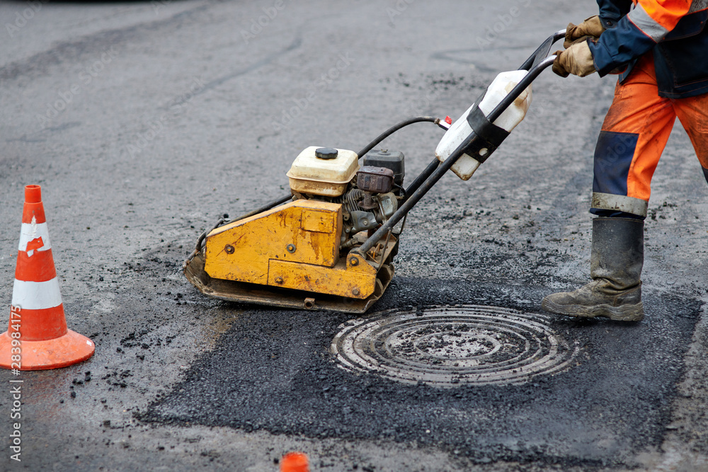 Stock-Foto „Construction worker in uniform operate vibratory plate ...
