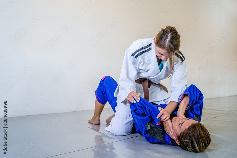 Two brazilian jiu jitsu BJJ women female athletes fighting in training ...