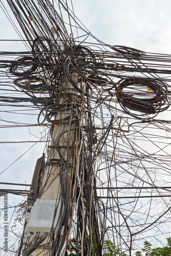 Phnom Penh, Cambodia. Rat's nest of electrical wiring. This is along one of Phnom Penh's streets ...