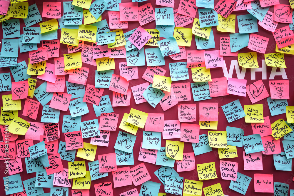 many sticky notes with the names of the loved ones on a wall, project ...