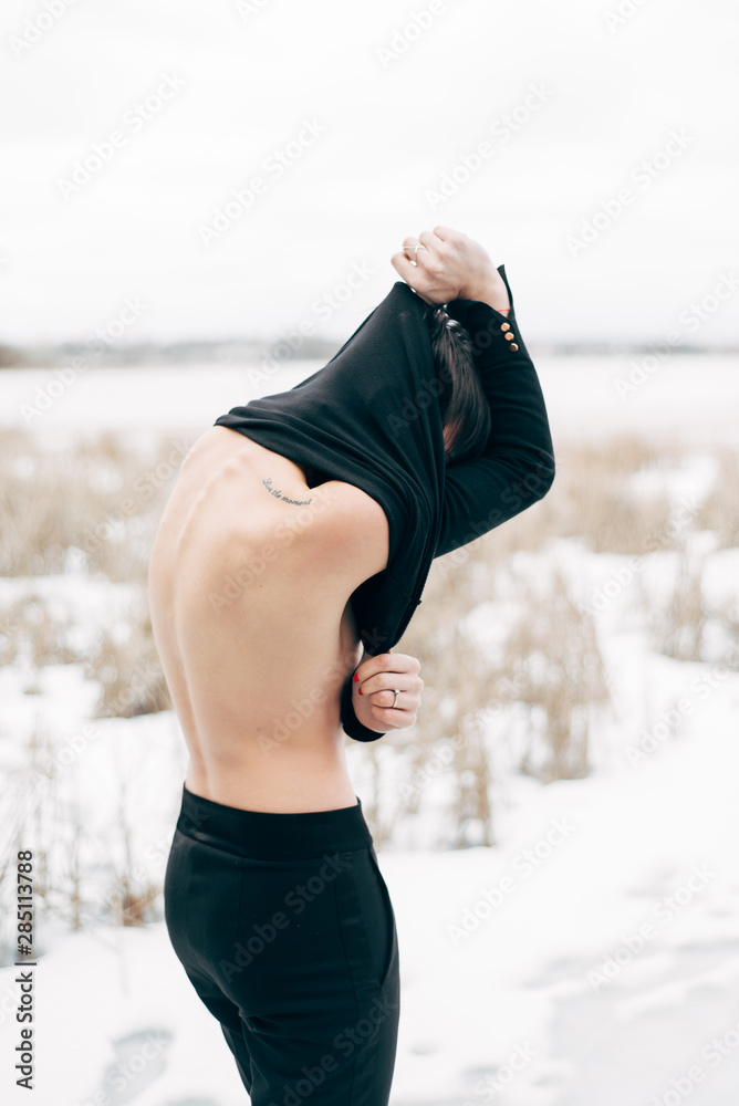 Woman taking off clothes in nature Stock Photo | Adobe Stock
