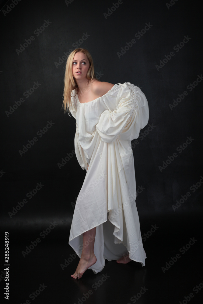 full length portrait of blonde girl wearing long white flowing robe ...
