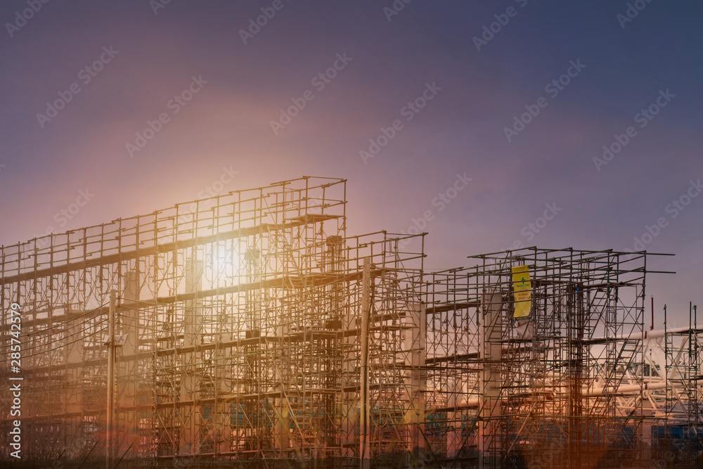 Construction site with scaffold tower and warning label building with ...