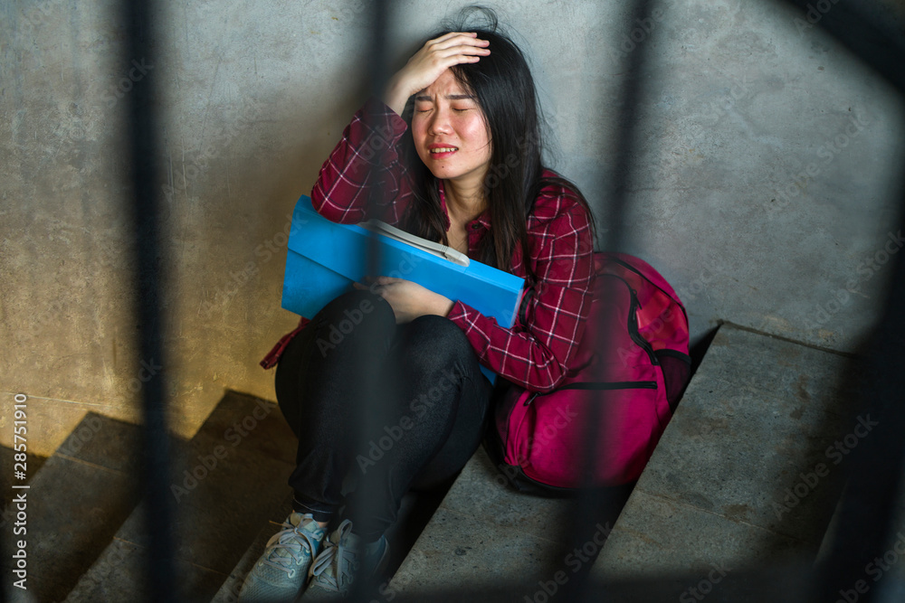 Dramatic portrait of Asian female college student bullied. Young depressed and sad Korean girl ...
