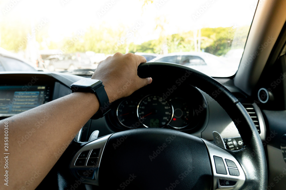 Driver's hands on the steering wheel inside of a car, Find a car park ...