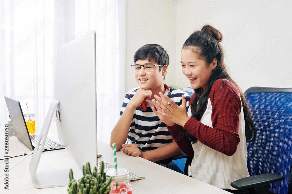 Happy excited mixed-race teenagers clapping when watching how the ...