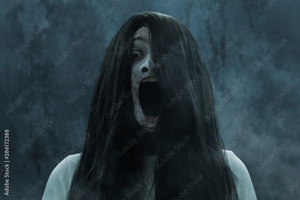Scary ghost woman screaming on dark background の Stock フォト | Adobe Stock