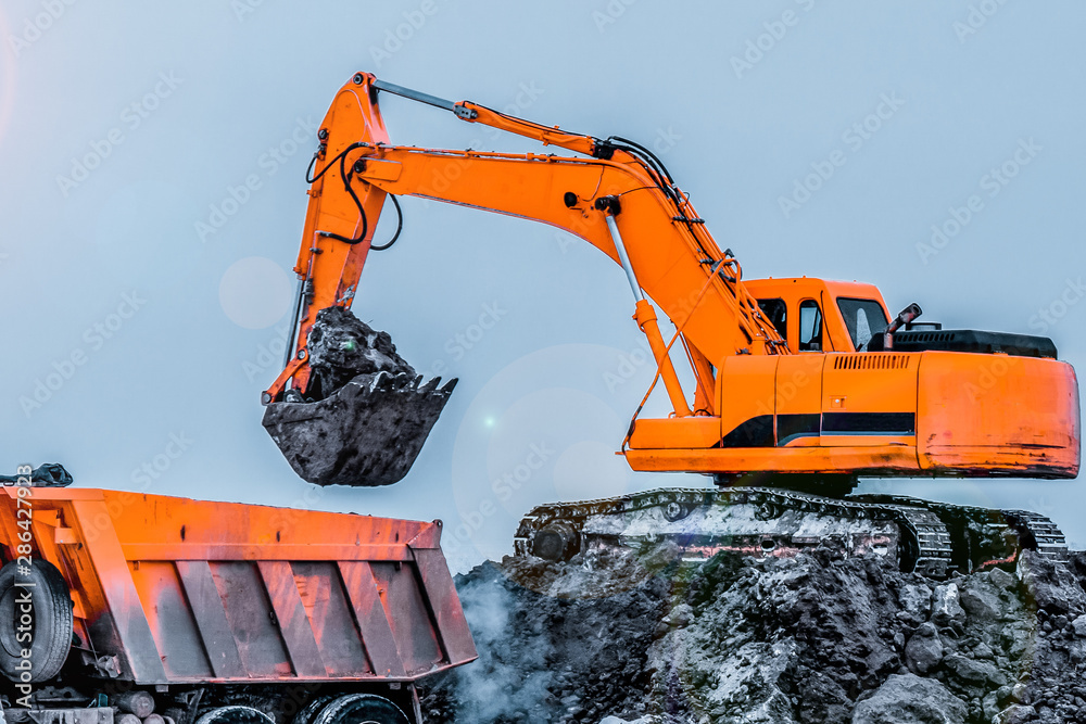 Excavator is loading excavation to the truck. Excavators hydraulic are ...