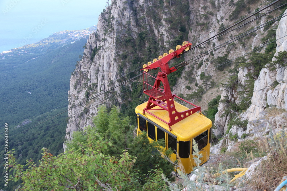 Yellow cable car of cable road, delivering tourists down from Ai-Petri ...