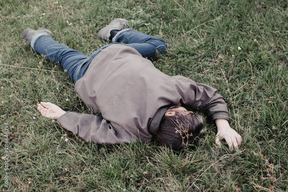 The corpse of a tramp in the grass. Criminal. Alcoholic intoxication ...