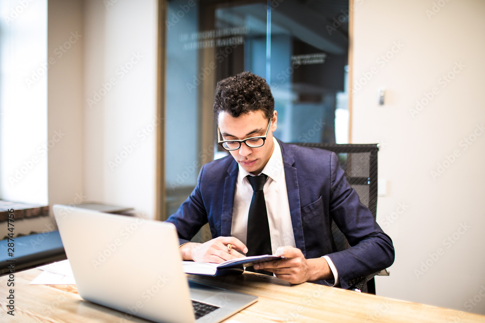 Man economist in glasses and formal suit reading from textbook about ...