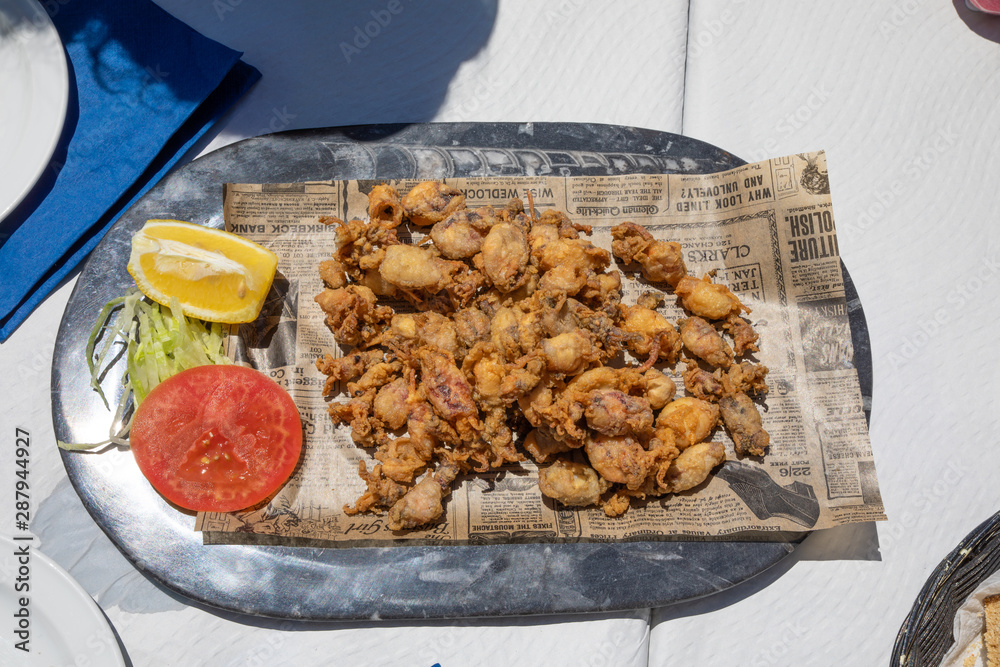 aerial view of grey tray with baby little squids breaded and fried ...