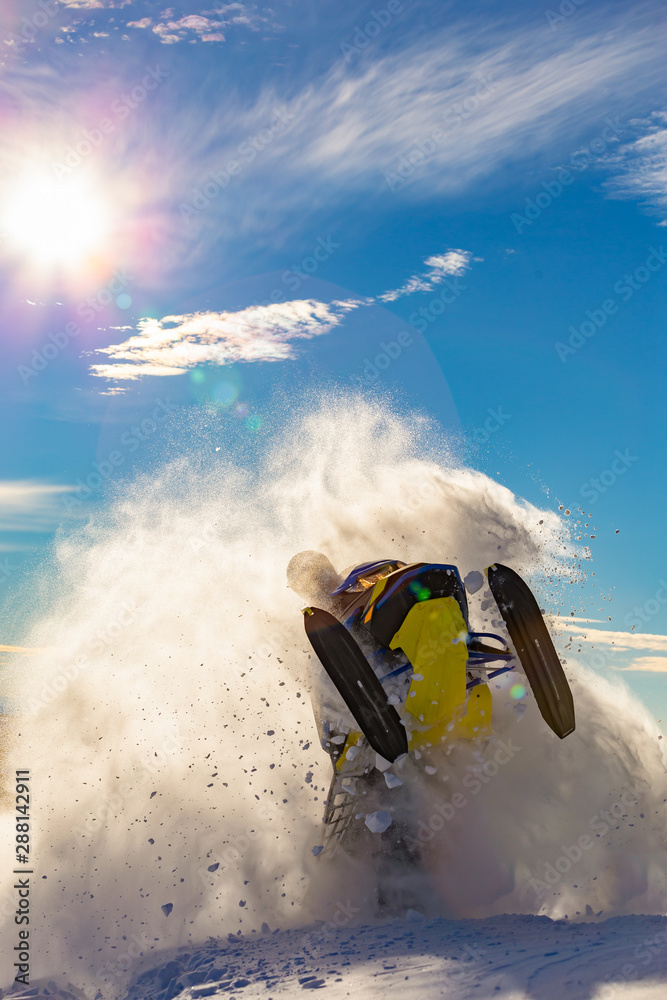 snowmobile jump. bright snowmobile in motion. the guy is flying on a ...