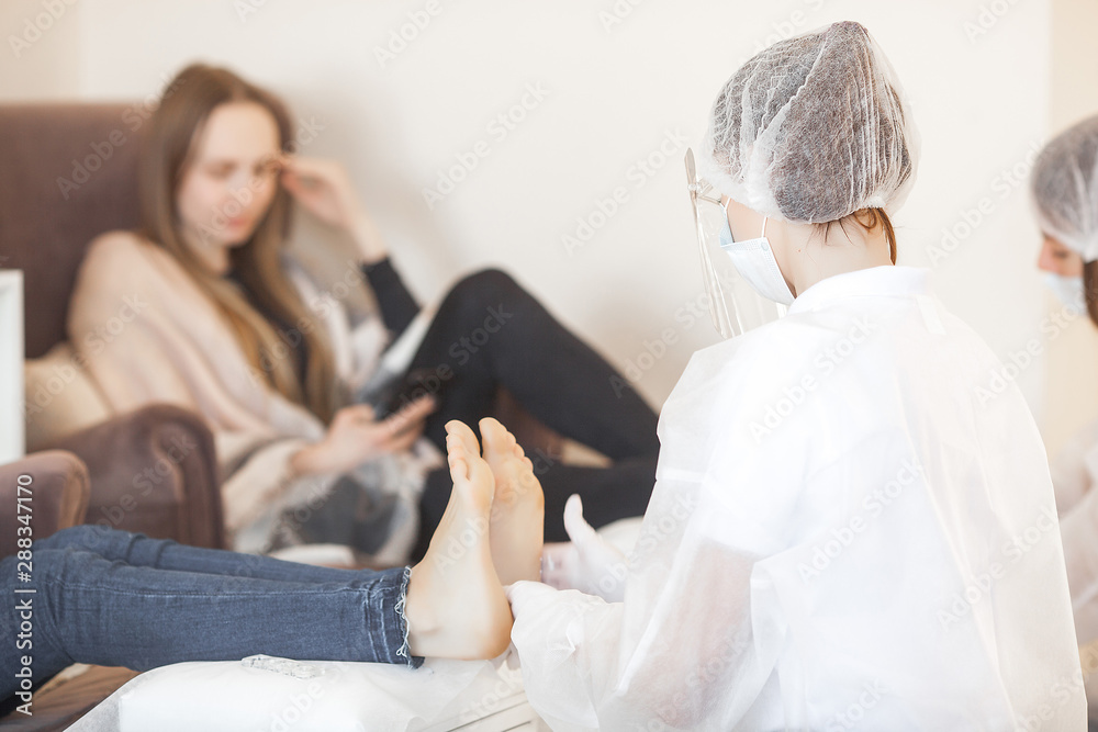 Pedicure in the salon. Master of pedicure doing a procedure for her ...