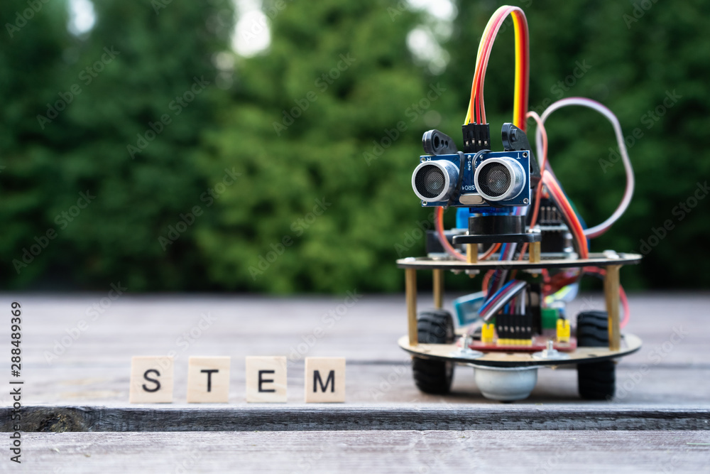 Hand made robot working on the electronic platform. Natural background ...