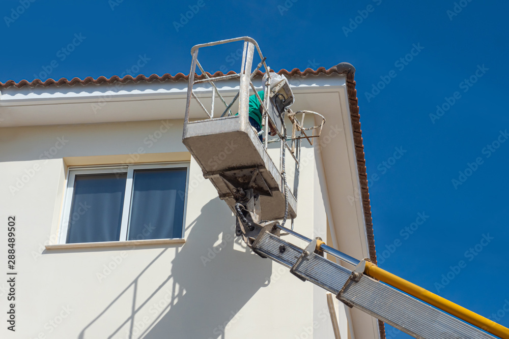 House painting. Painting the building. The painter works at height ...