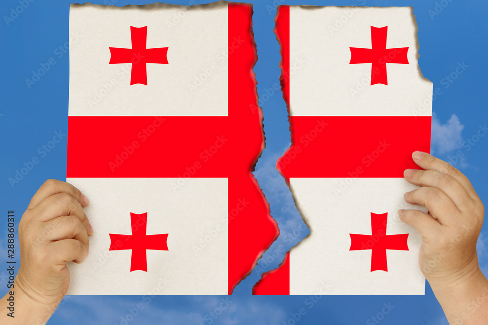 woman holds in both hands against a blue sky torn in two cardboard with ...