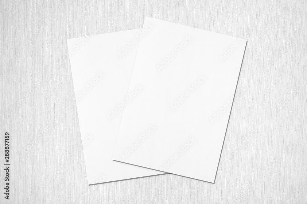 Two empty white rectangle poster or card mockups lying diagonally on ...