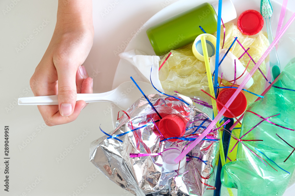 Eating plastic trash or consuming junk food concept. Environmental ...