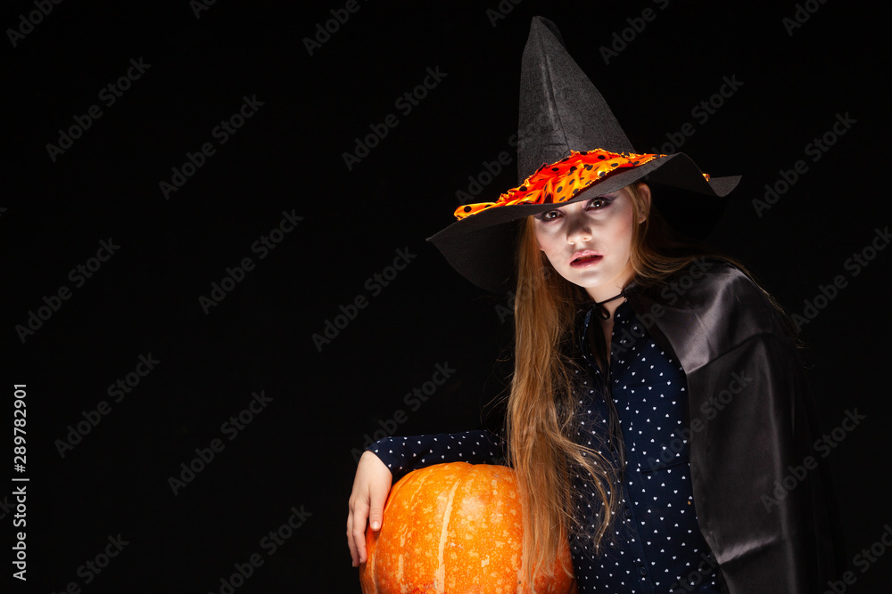 Halloween Witch with Pumpkin on black background. Beautiful young ...