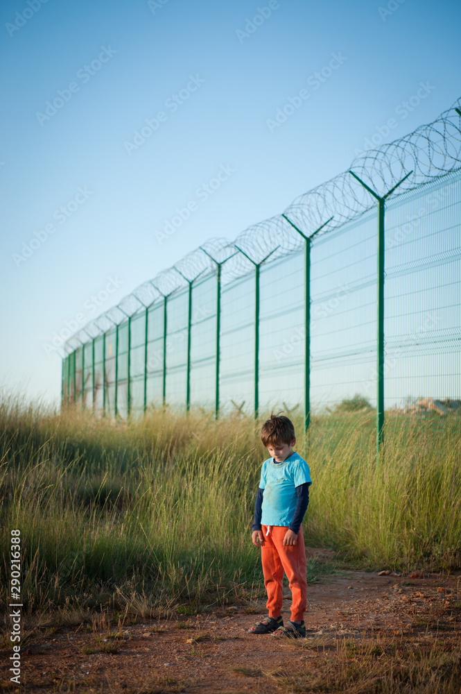 migration concept one lonely poor kid refugee standing sad on state ...